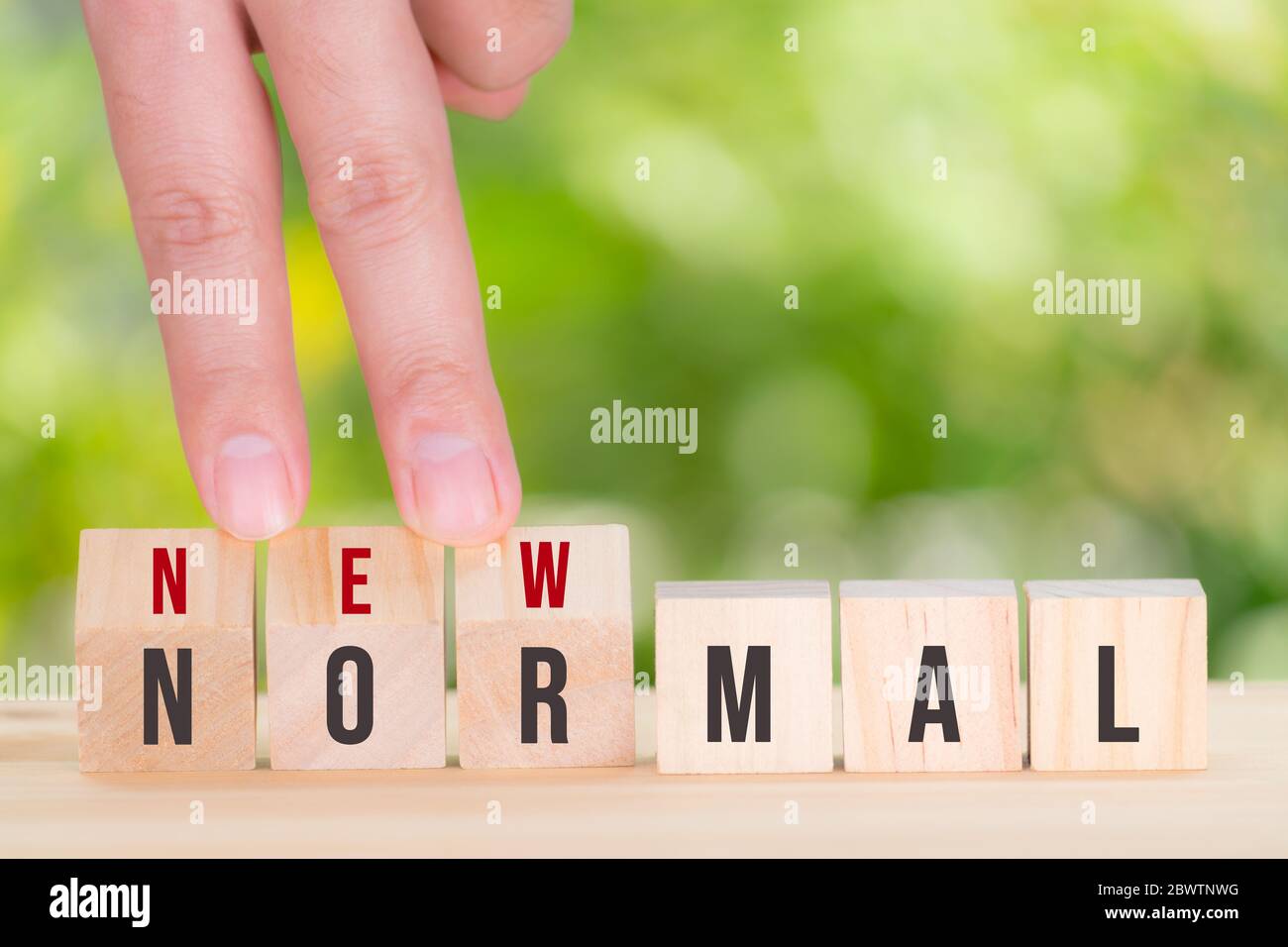 Hands flip wooden cube "NEW NORMAL". The new normal after COVID-19 ...