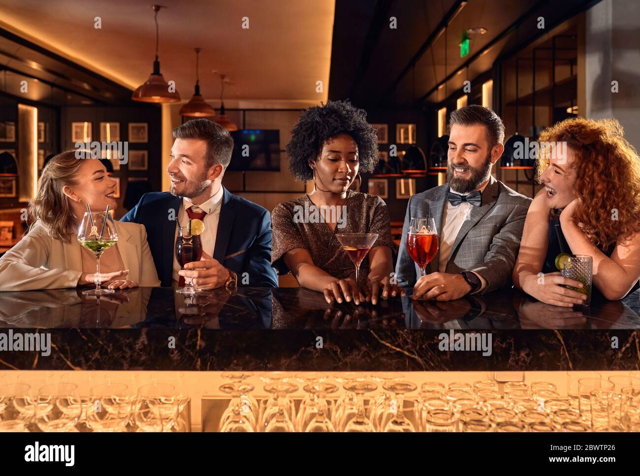 Happy friends socializing in a bar Stock Photo - Alamy
