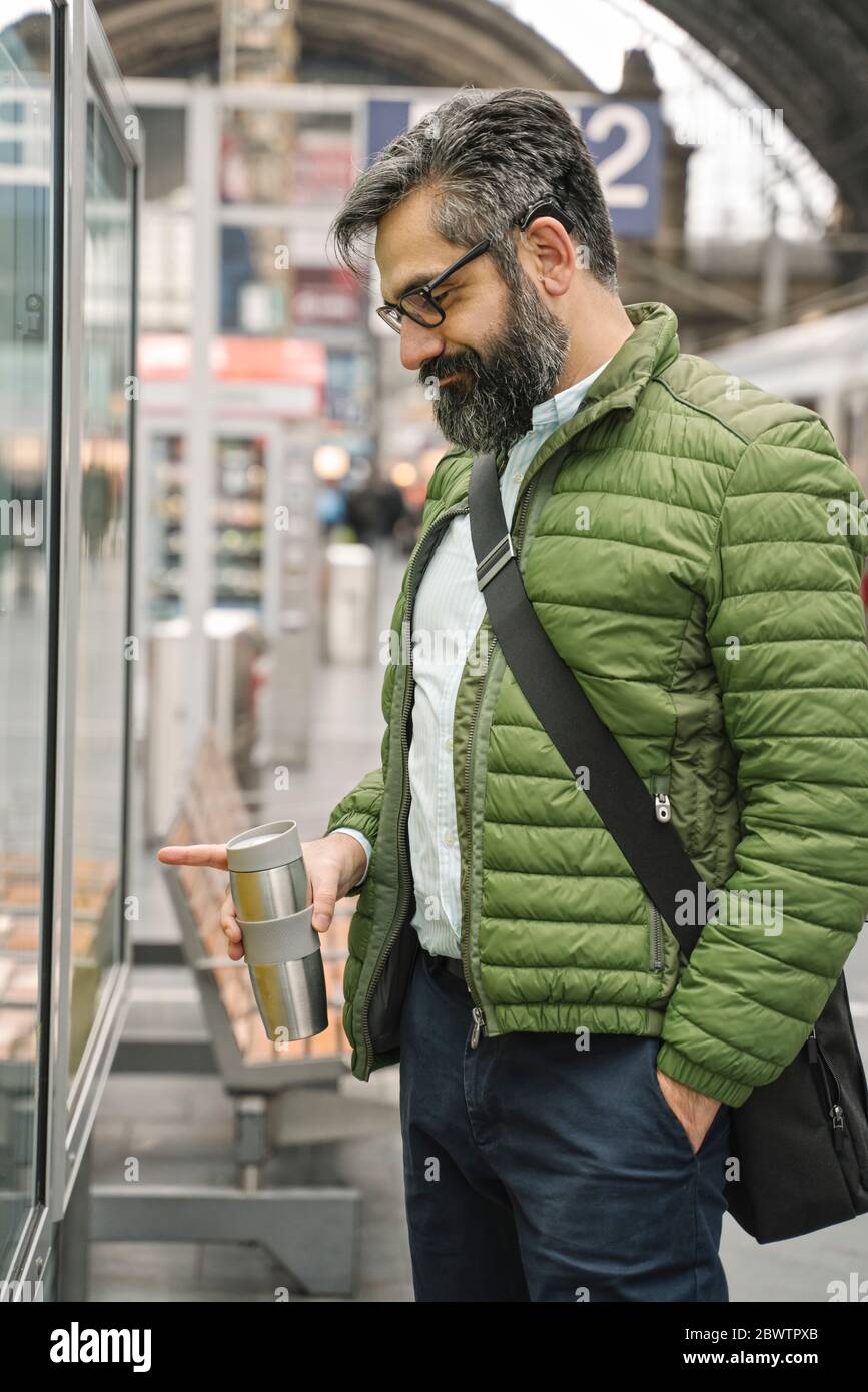 Man checking the timetable at the train station Stock Photo - Alamy
