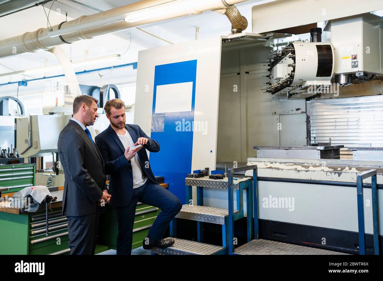 Two businessmen having meeting factory hall hi-res stock photography ...