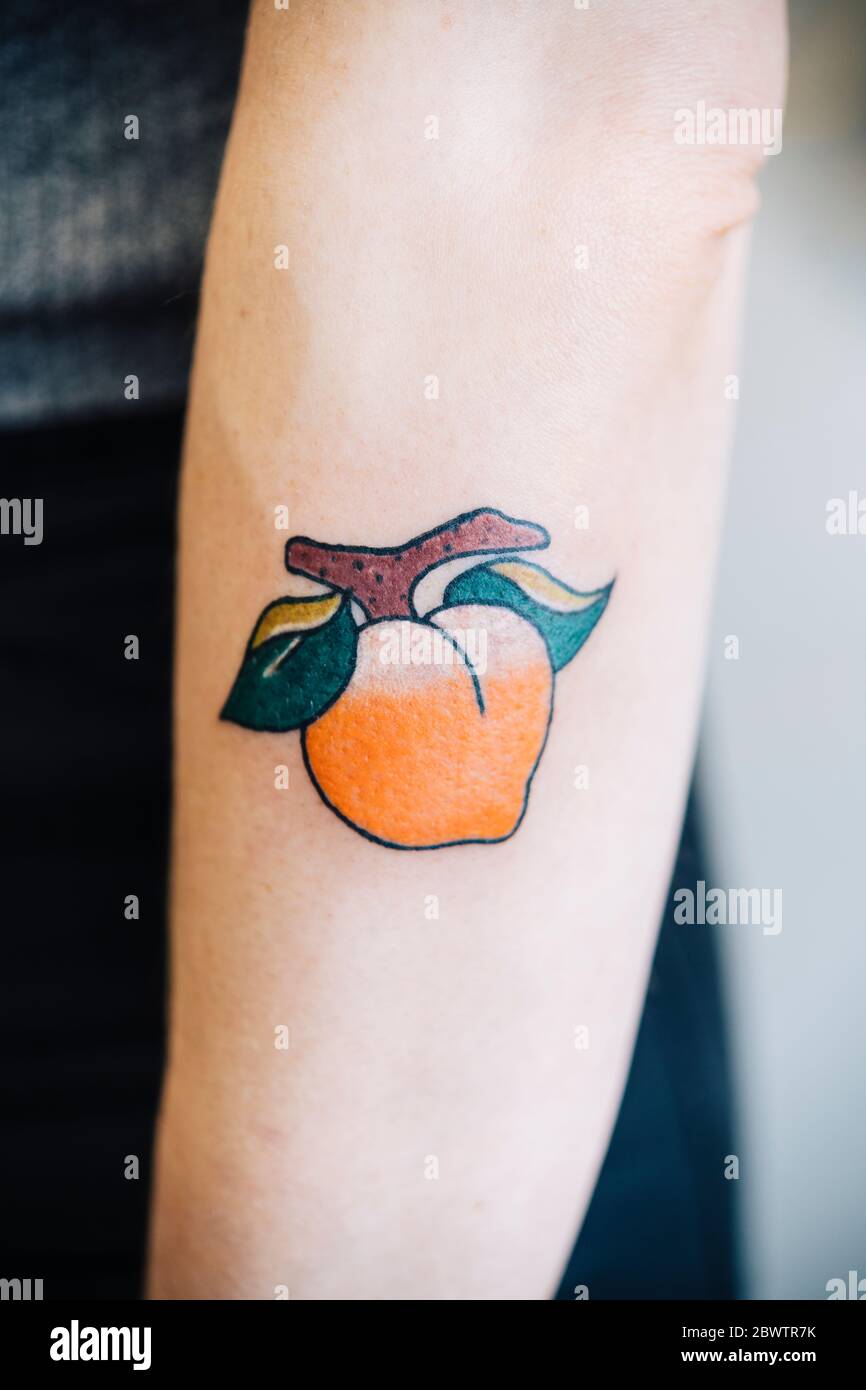 Peach tattooed on woman's arm Stock Photo - Alamy