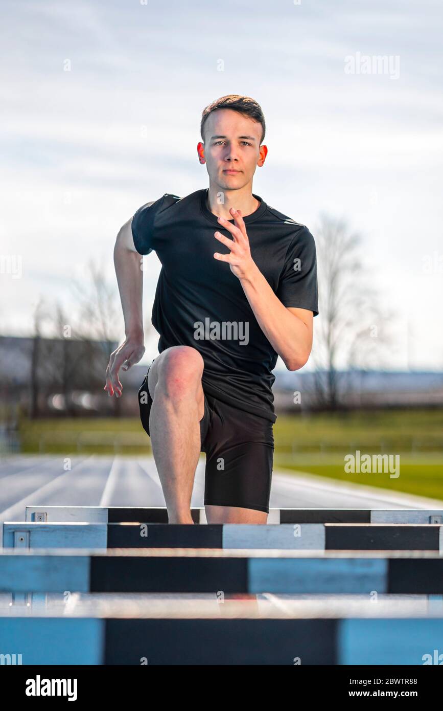 Athlete crossing a hurdle Stock Photo - Alamy