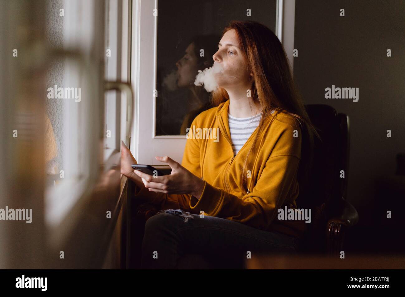 Woman smoking by window hi-res stock photography and images - Alamy