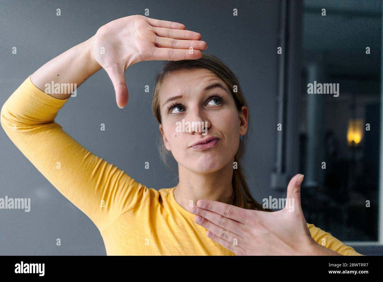 Portrait of sceptical young woman making a finger frame Stock Photo - Alamy
