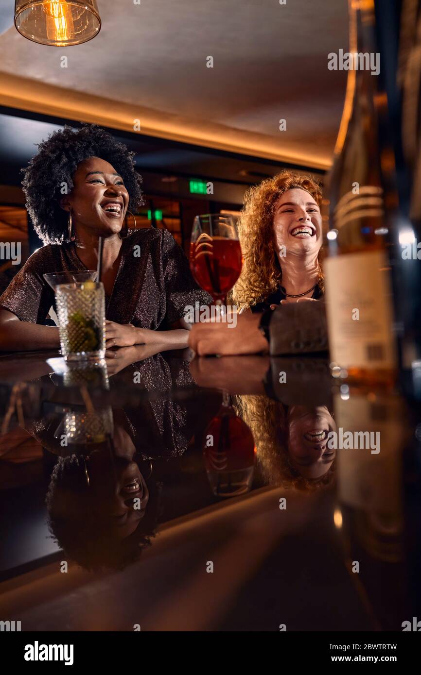 Happy friends socializing in a bar Stock Photo - Alamy