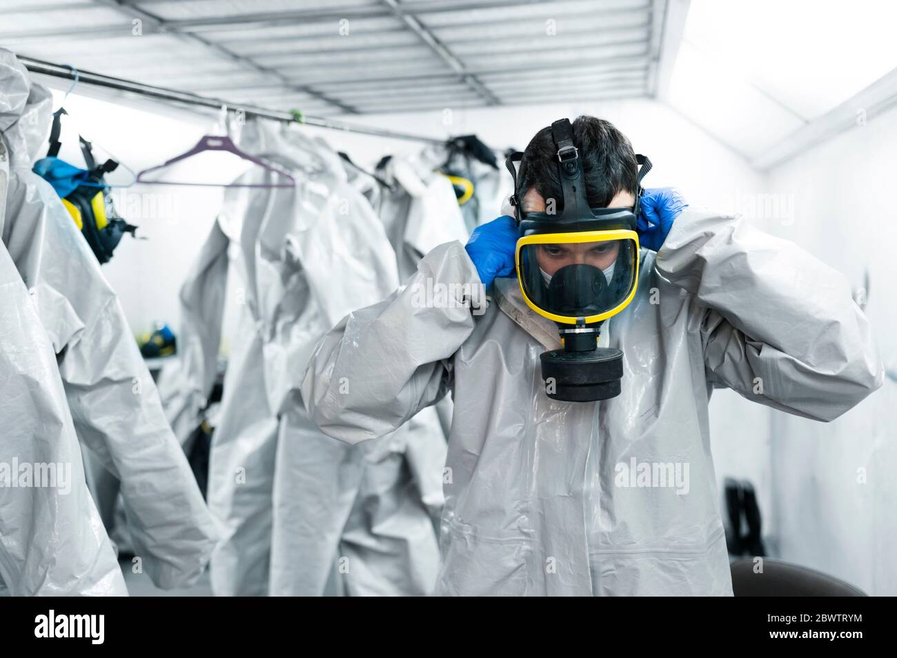 Sanitation worker wearing gas mask while standing by protective ...