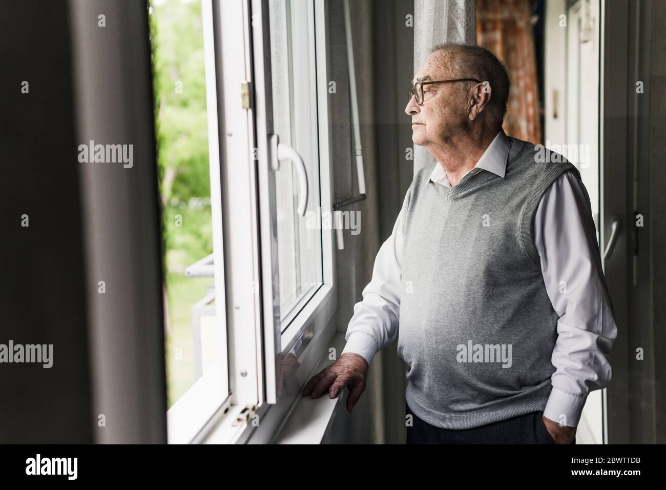 Pensive senior man looking out of window Stock Photo - Alamy
