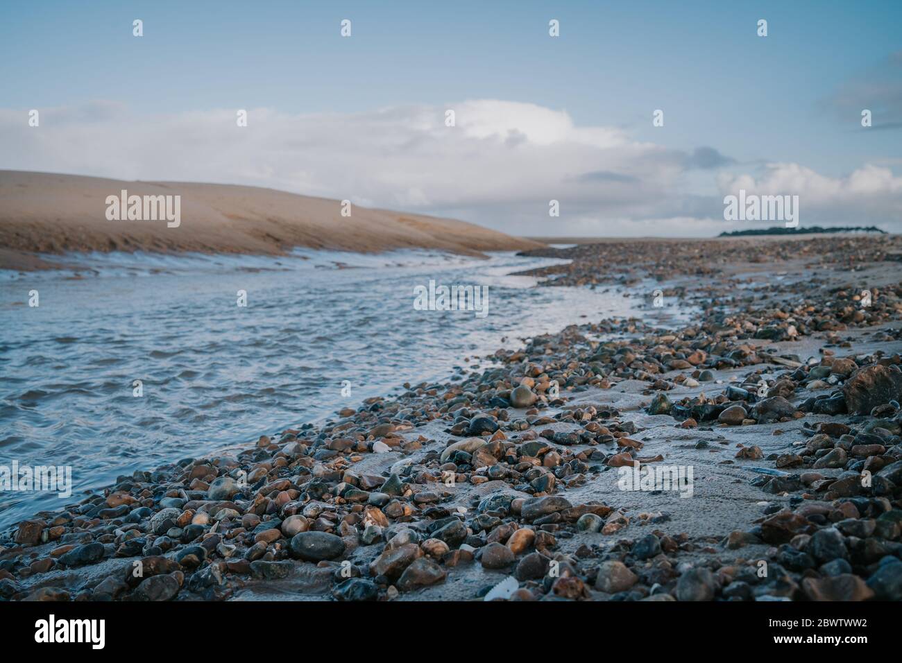 Stream of water surrounded by sand dunes at Holkham beach on the North ...
