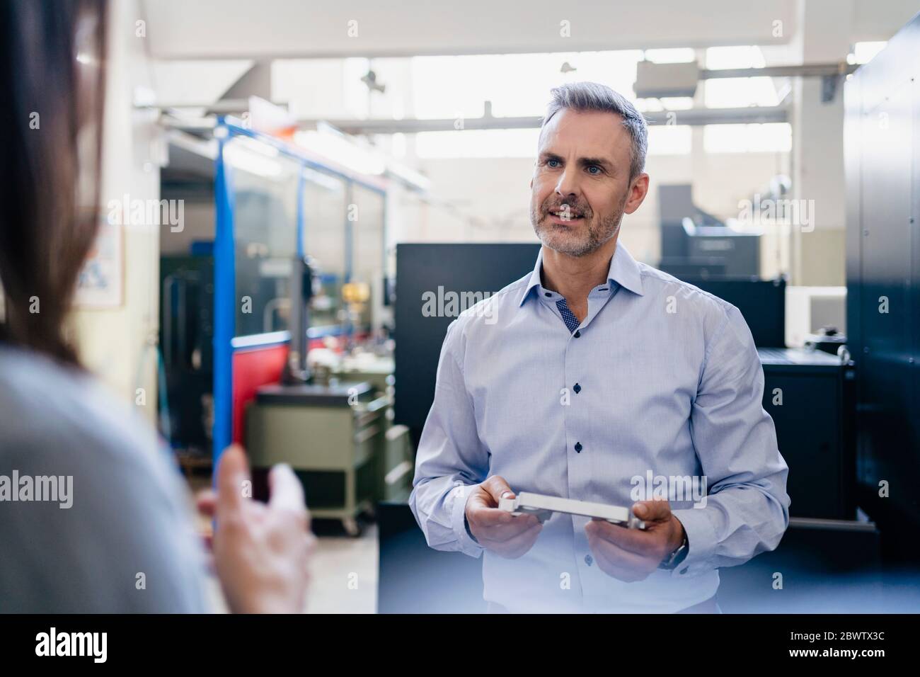 Businessman and businesswoman having a work meeting in a factory Stock ...
