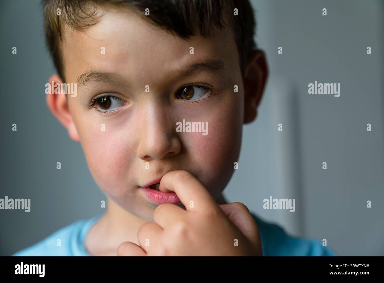 Portrait of little boy with finger in mouth Stock Photo - Alamy