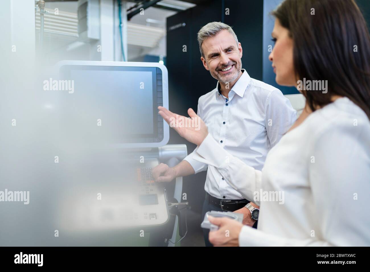 Businessman and businesswoman having a work meeting in a factory Stock ...
