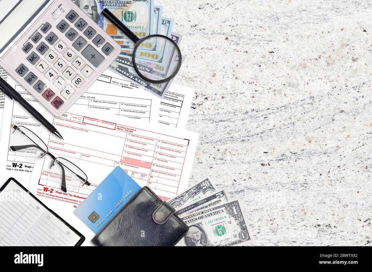 IRS form W-2 wage and tax statement lies on flat lay office table and ...