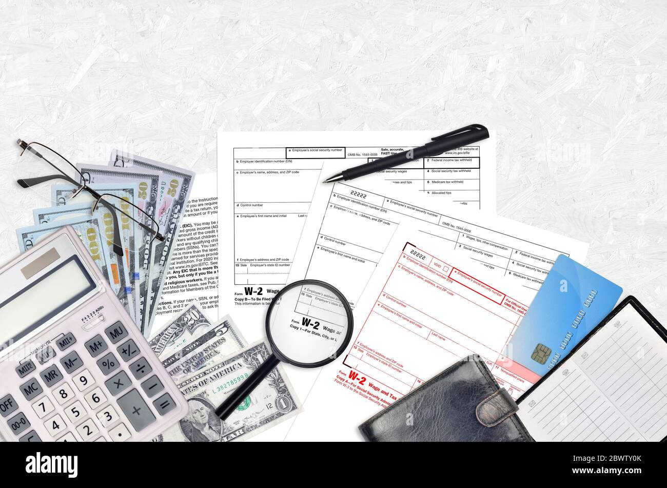 IRS form W-2 wage and tax statement lies on flat lay office table and ...