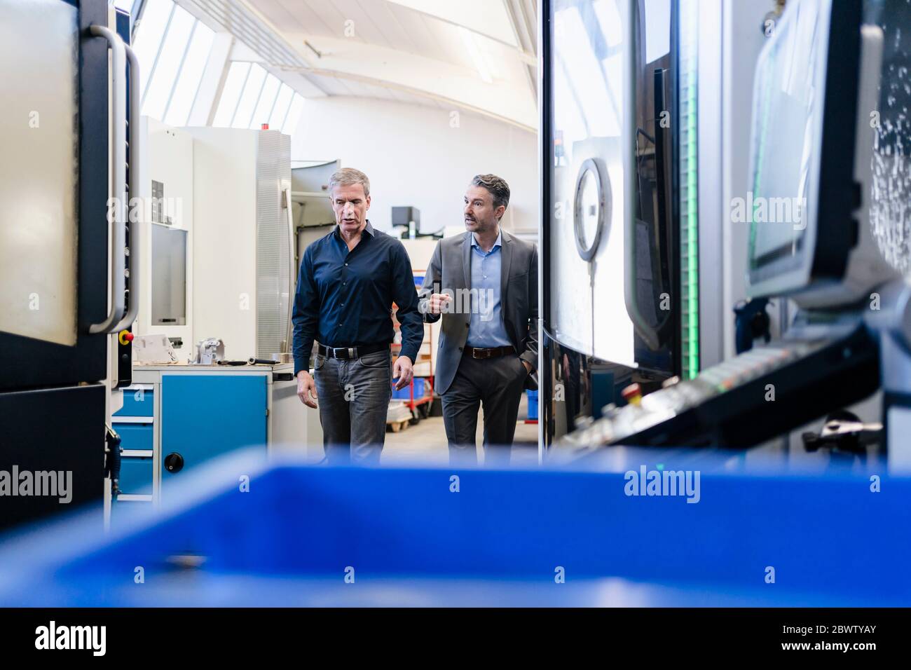 Two businessmen having meeting factory hall hi-res stock photography ...