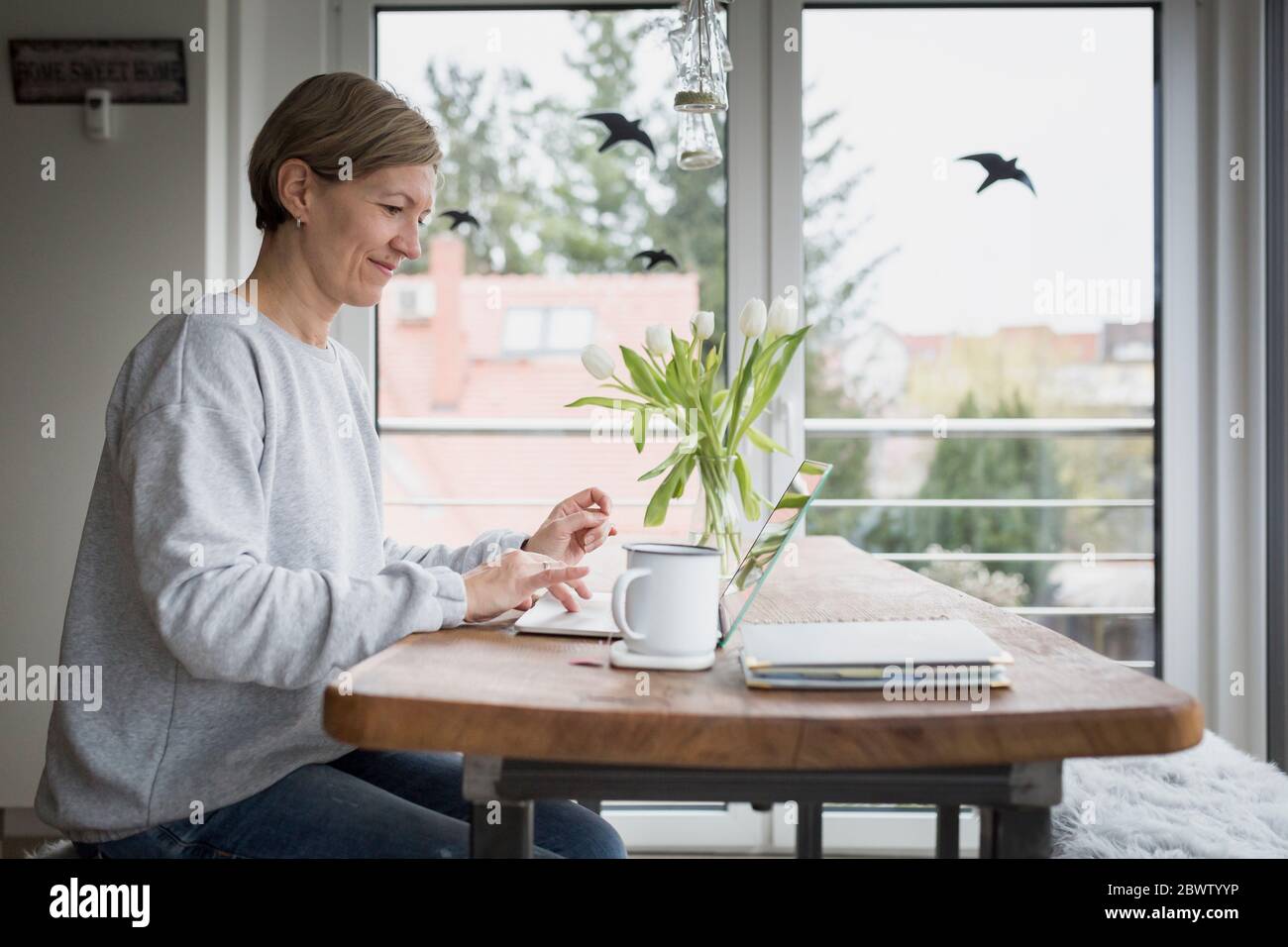 Mature woman working from home, using laptop Stock Photo - Alamy