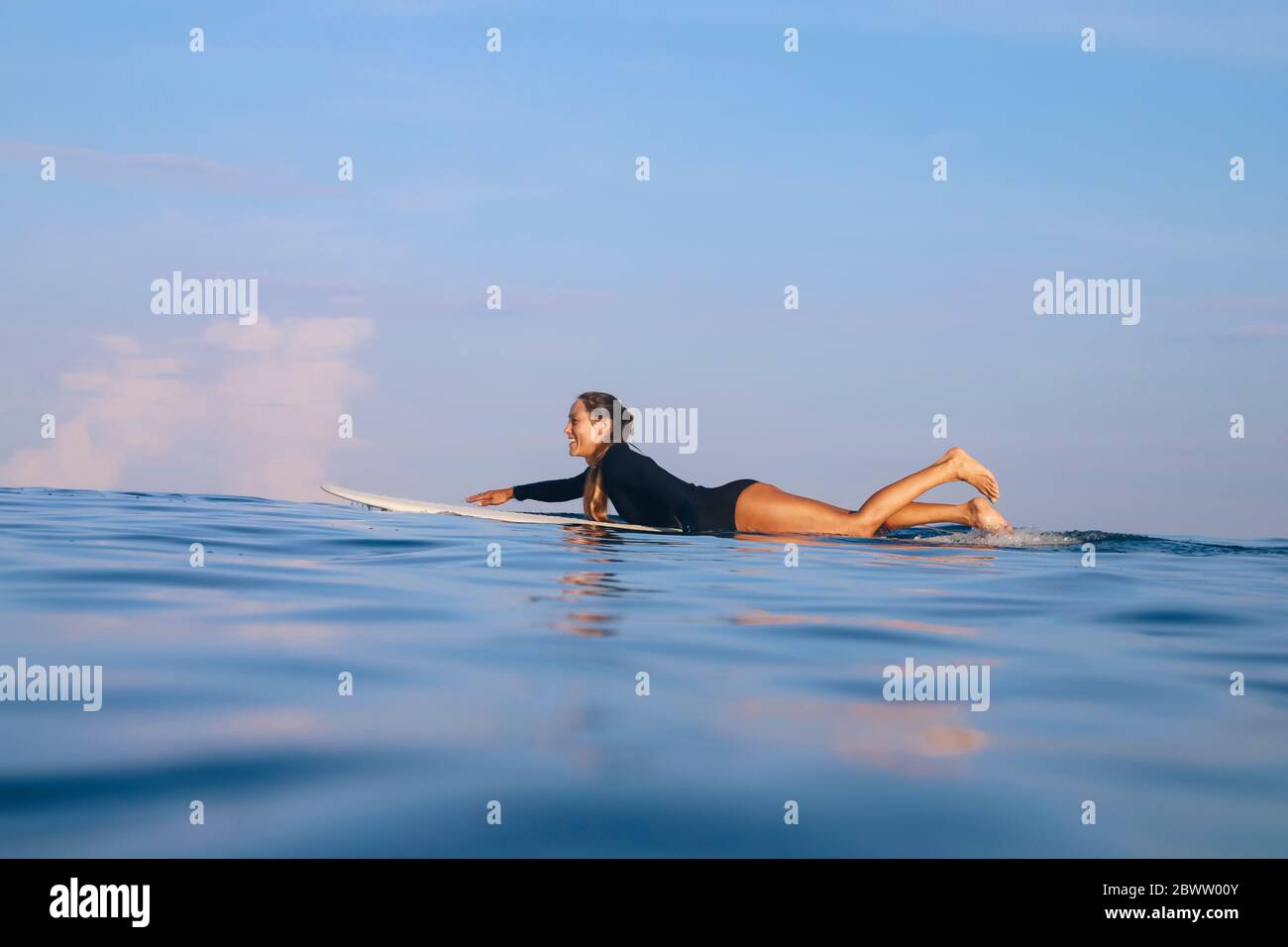 Happy woman lying on surfboard in the sea, Bali, Indonesia Stock Photo ...