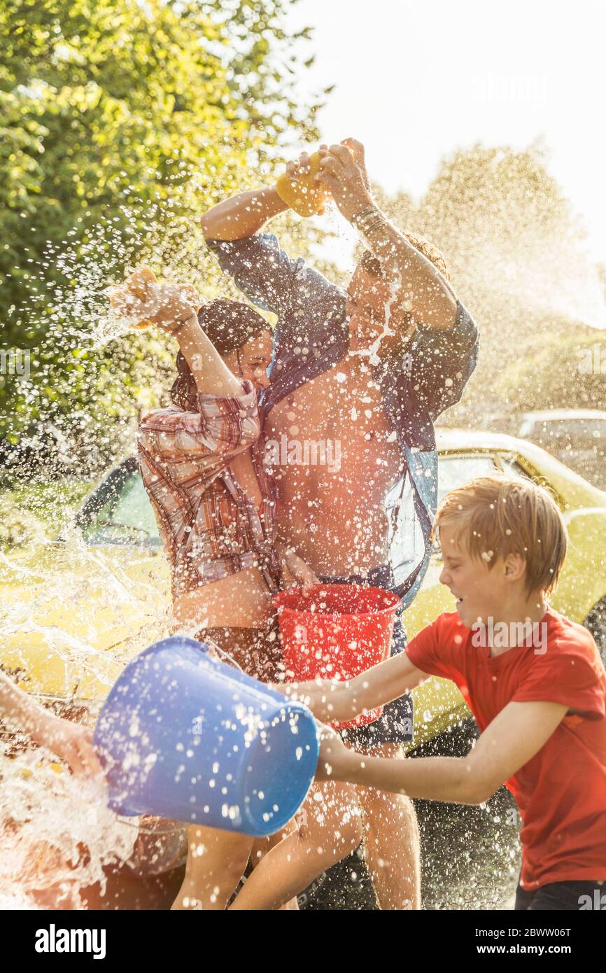 Friends washing yellow vintage car in summer having fun Stock Photo - Alamy