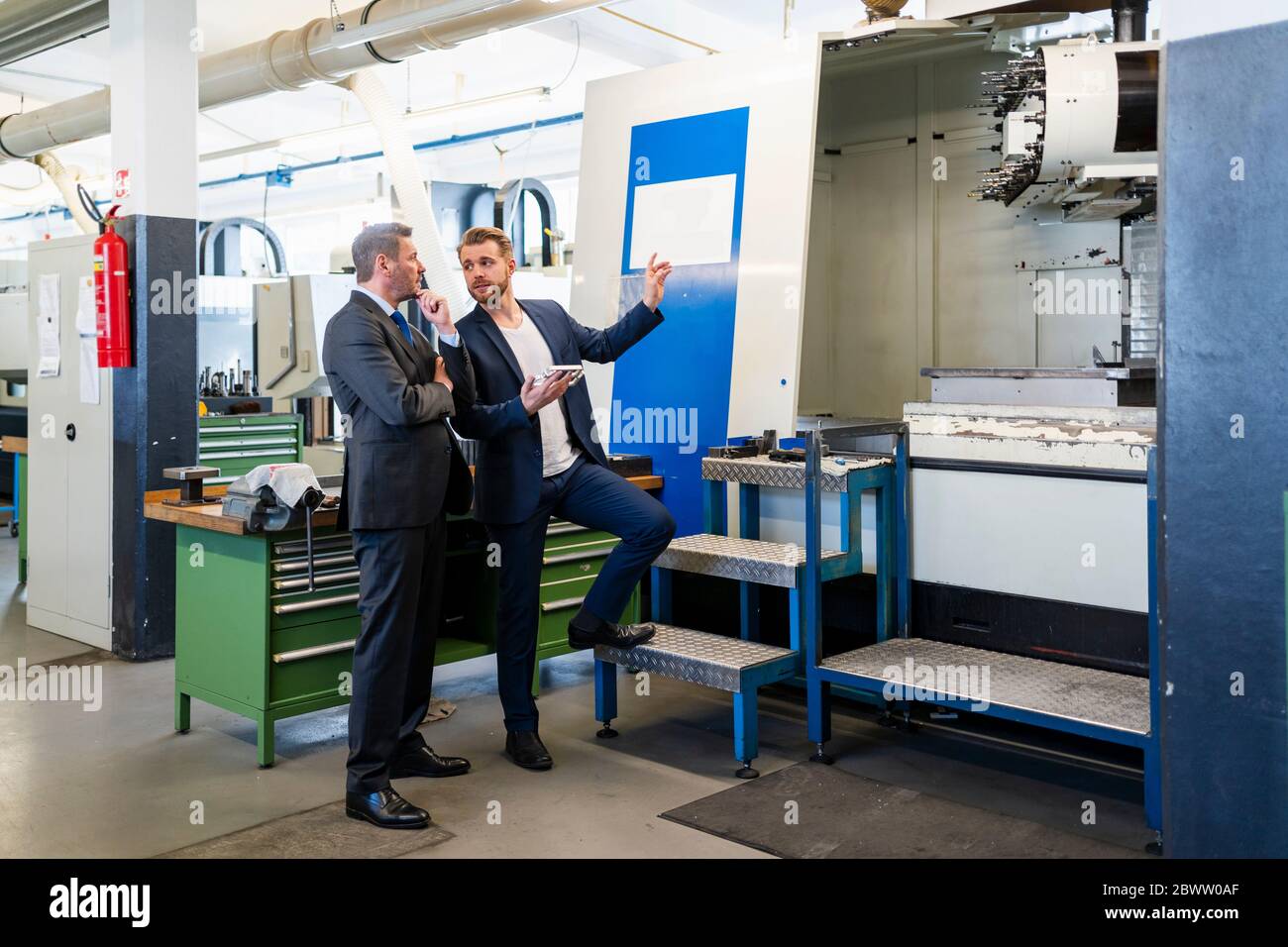 Two businessmen having a work meeting in a factory Stock Photo - Alamy