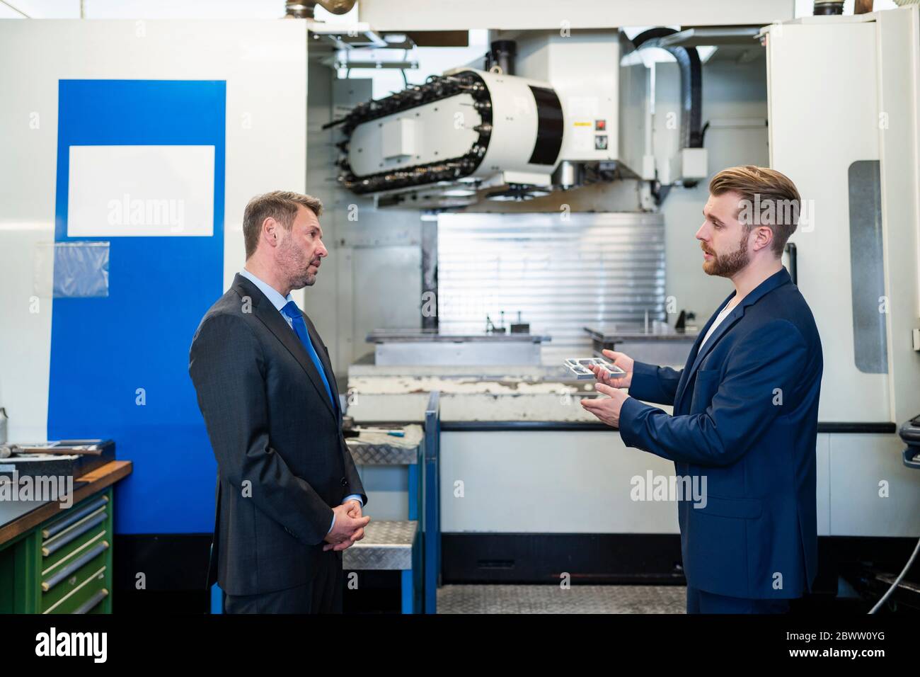 Two businessmen having meeting factory hall hi-res stock photography ...