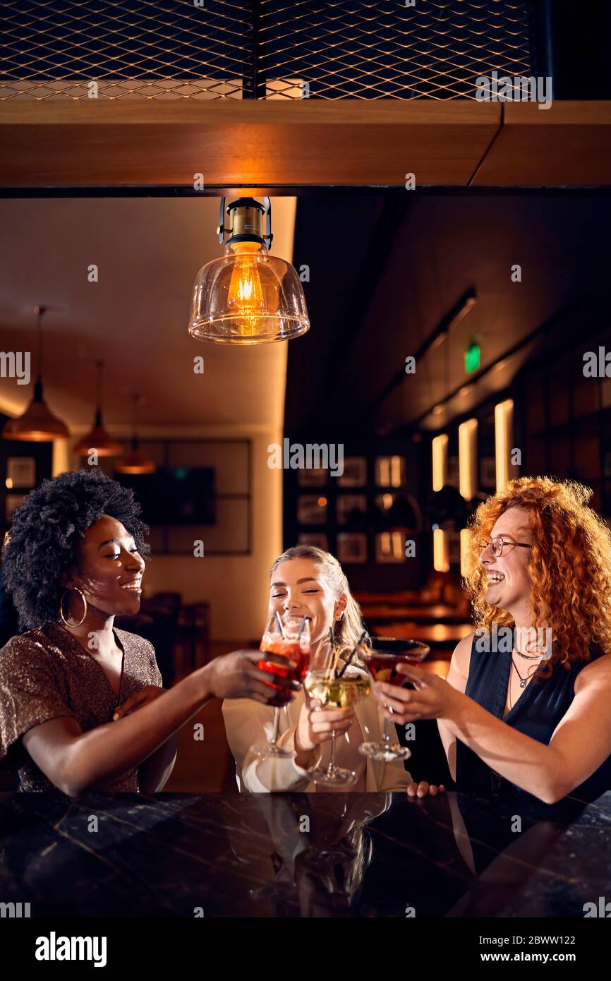 Happy friends socializing in a bar with cocktails Stock Photo - Alamy