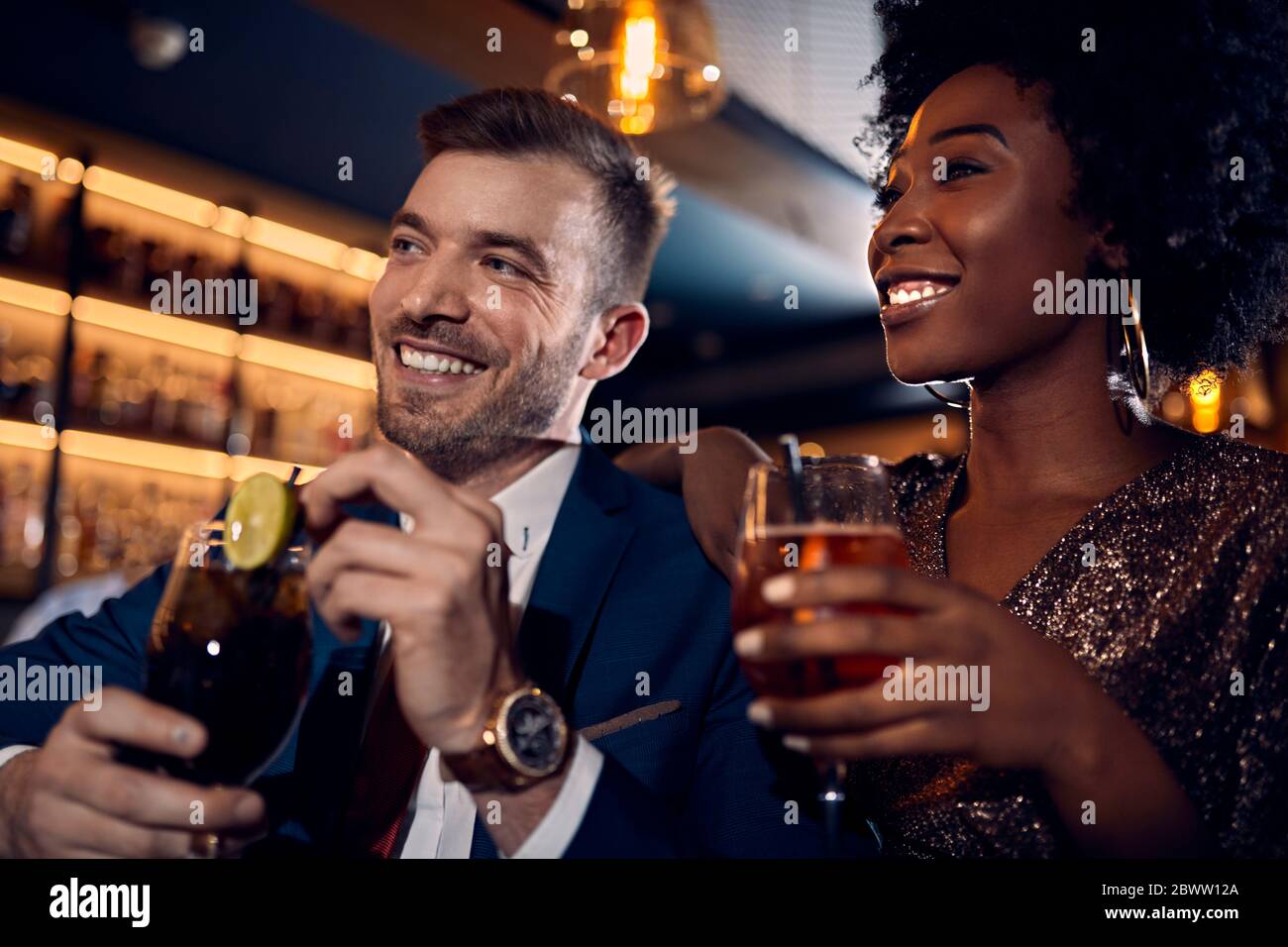 Happy couple socializing in a bar Stock Photo - Alamy