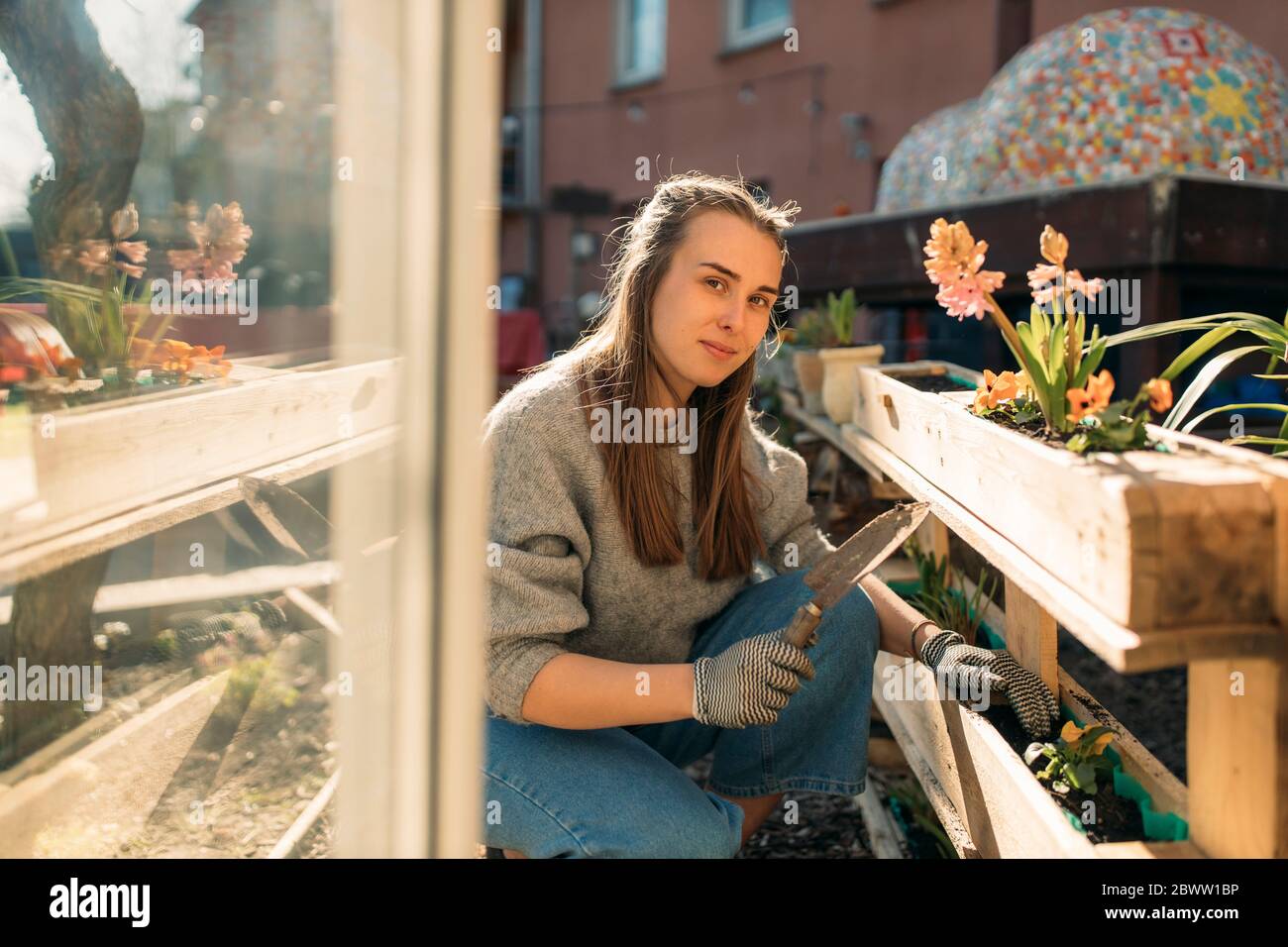 Portrait of young woman working in garden in sunshine Stock Photo - Alamy