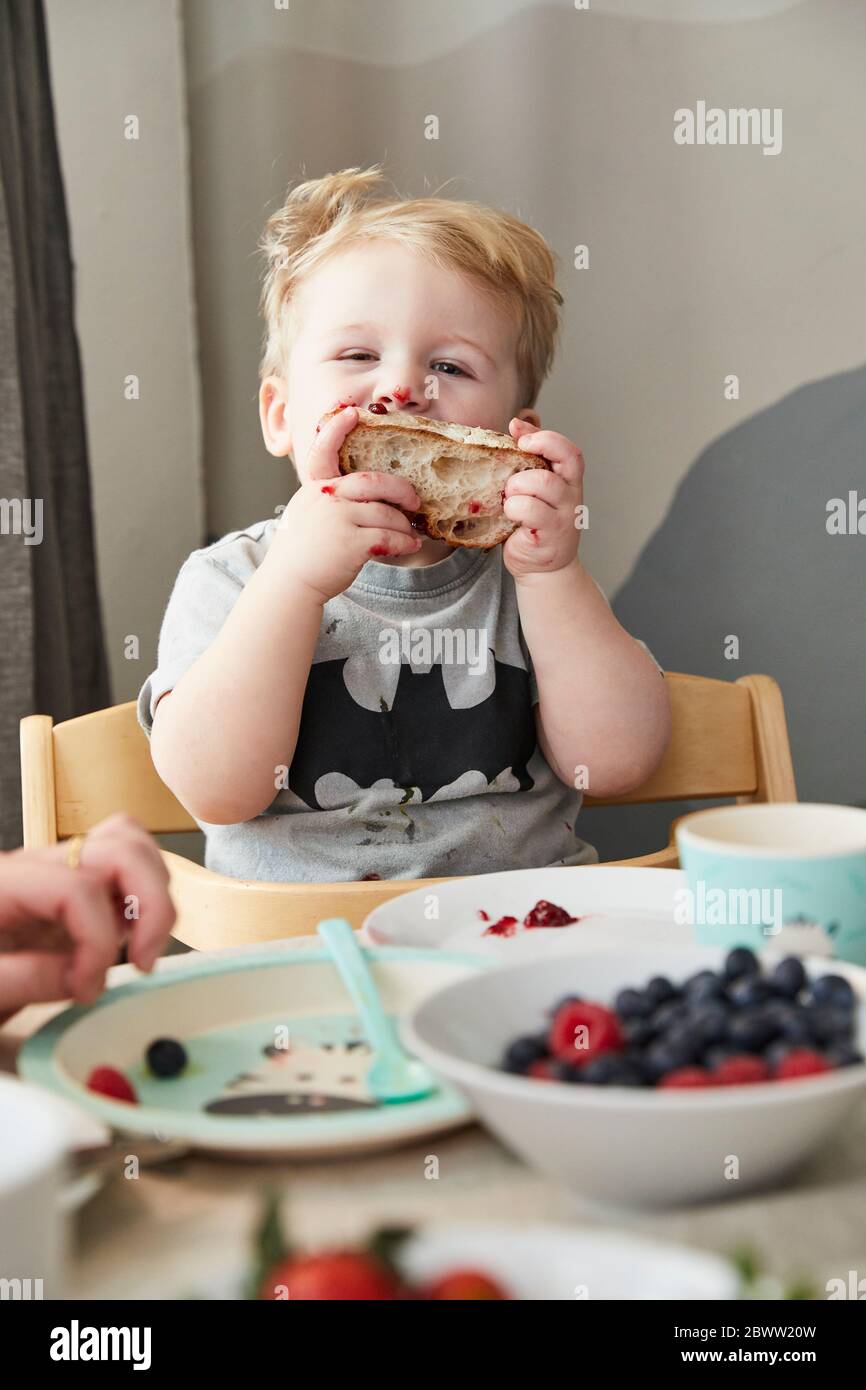 Portrait of smeared little boy eating bread with jam Stock Photo - Alamy