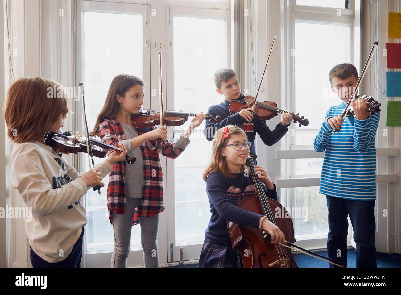 Group of children playing violin during a lesson Stock Photo - Alamy