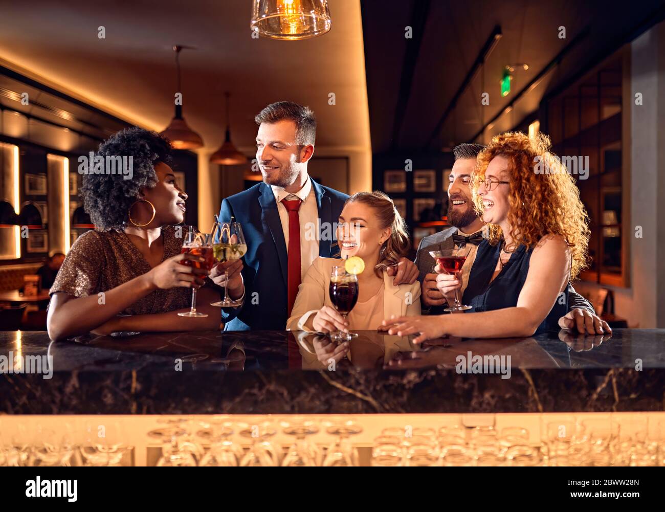 Happy friends socializing in a bar with cocktails Stock Photo - Alamy