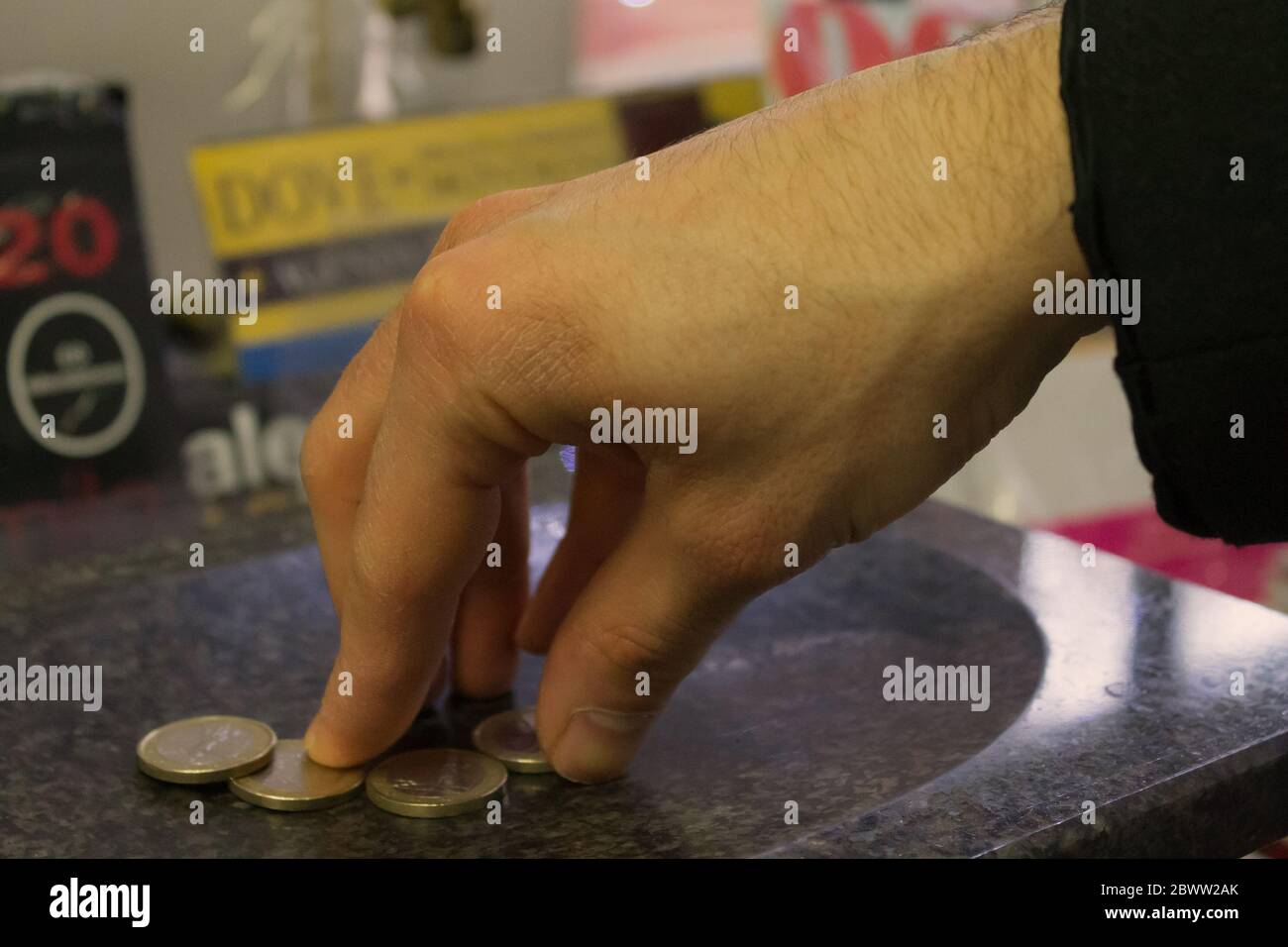 Man hand paying euros coins in a retail store Stock Photo - Alamy