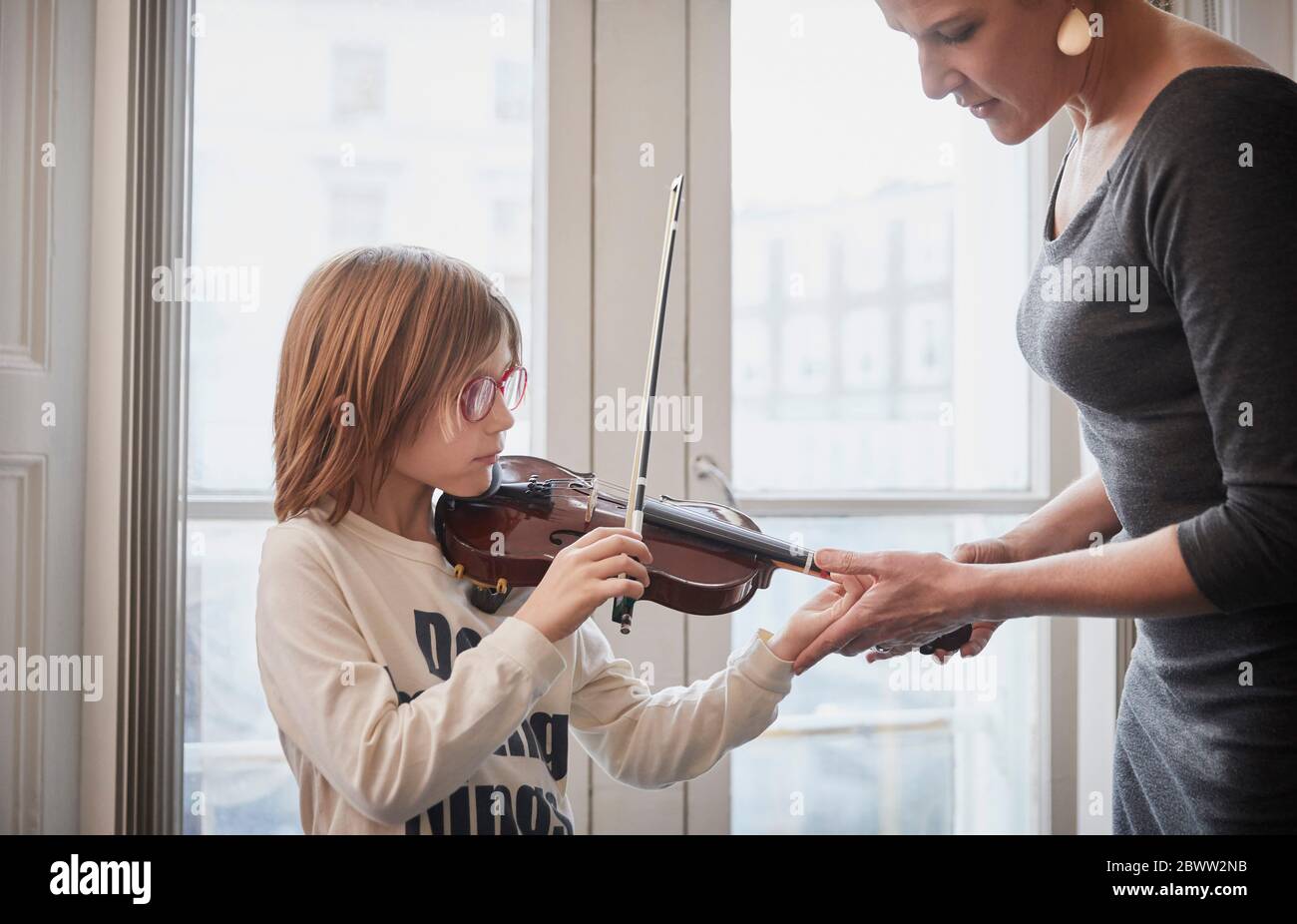 Teacher teaching boy playing violin during a lesson Stock Photo - Alamy