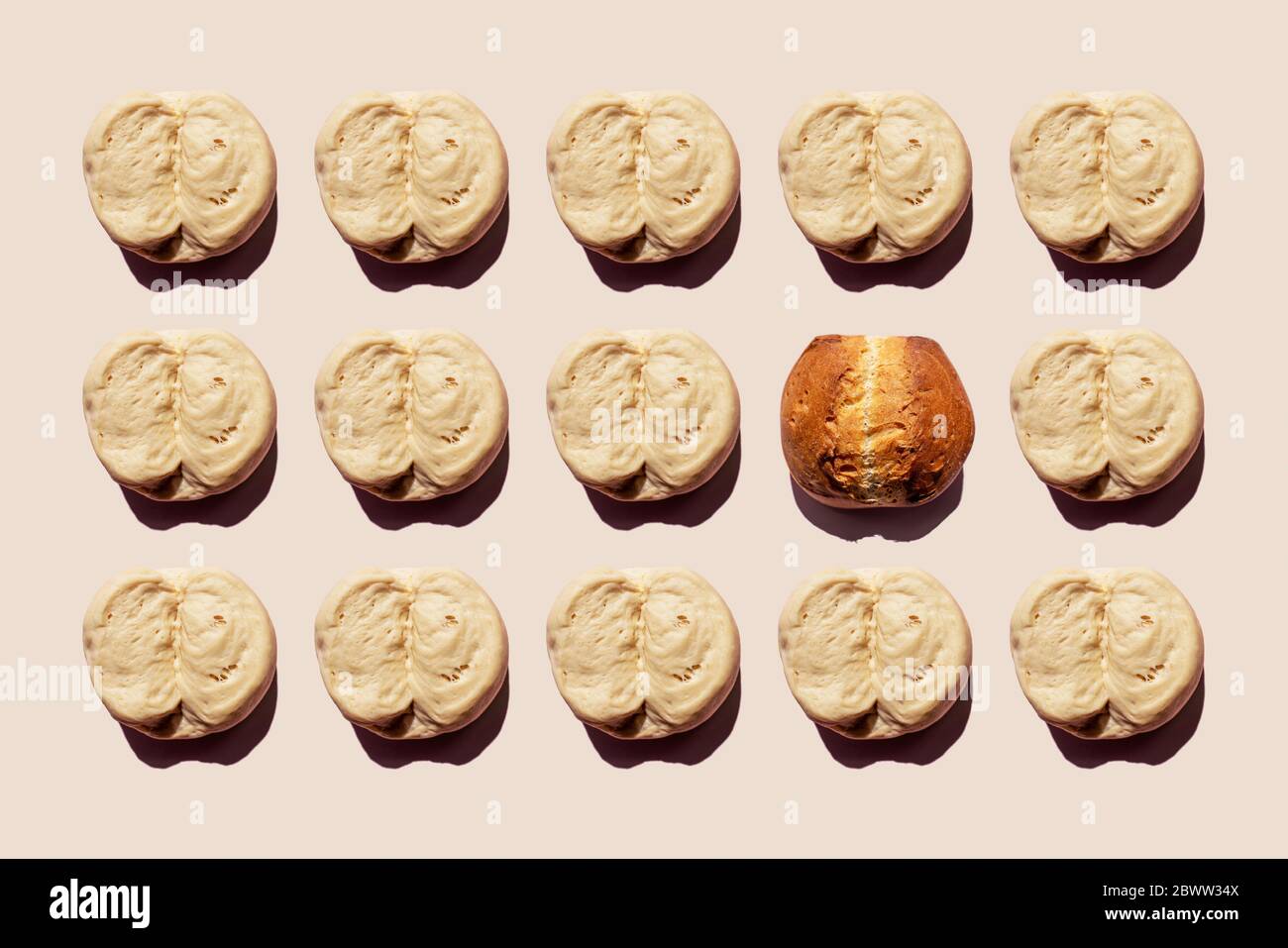 Studio shot of rows of raw dough lumps and single baked bread Stock ...