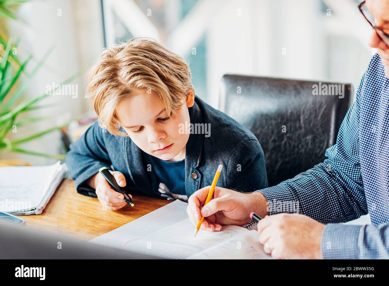 Father helping son doing homework at desk Stock Photo - Alamy