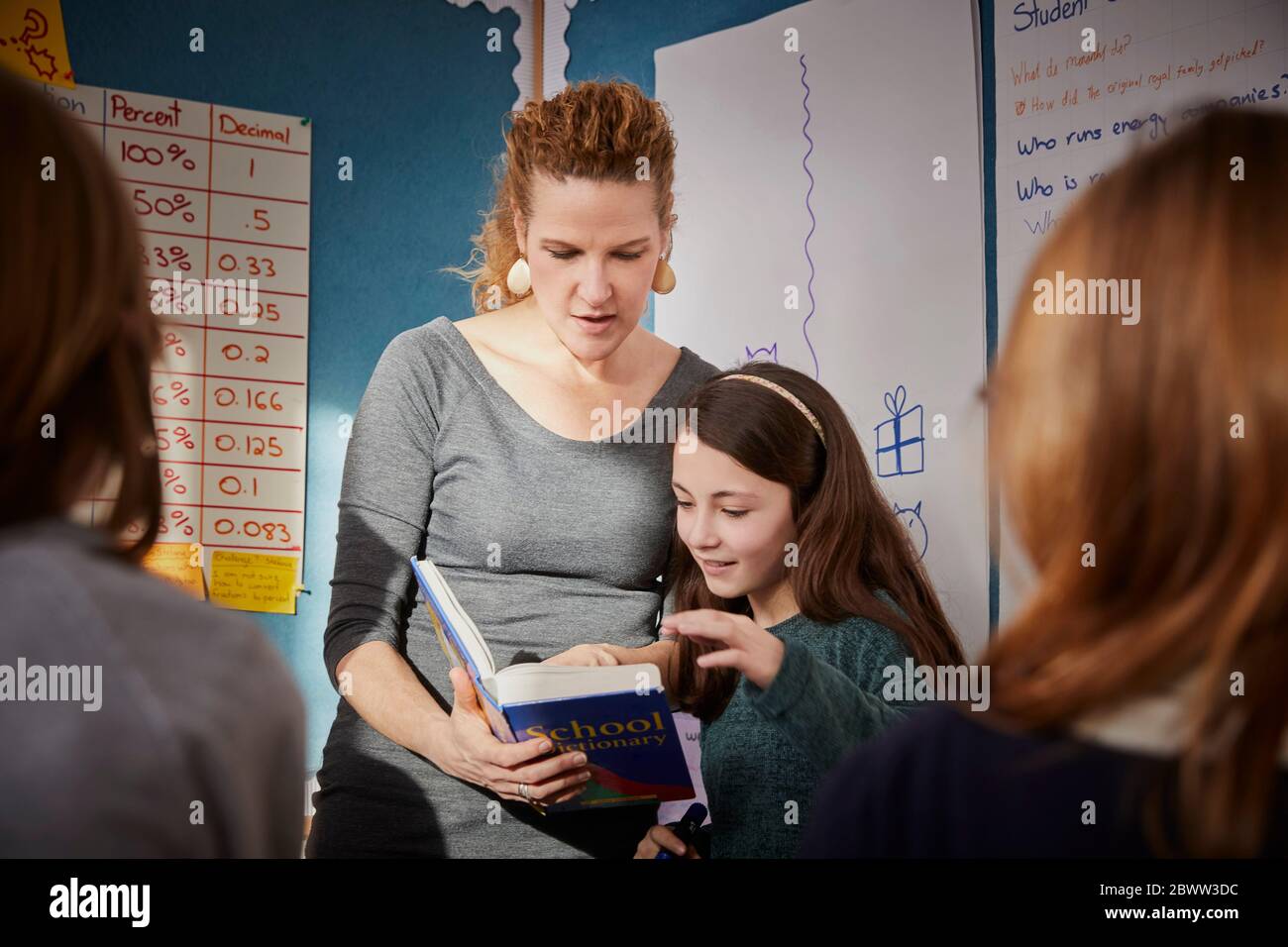 Girl and teacher in a class during a lesson Stock Photo - Alamy