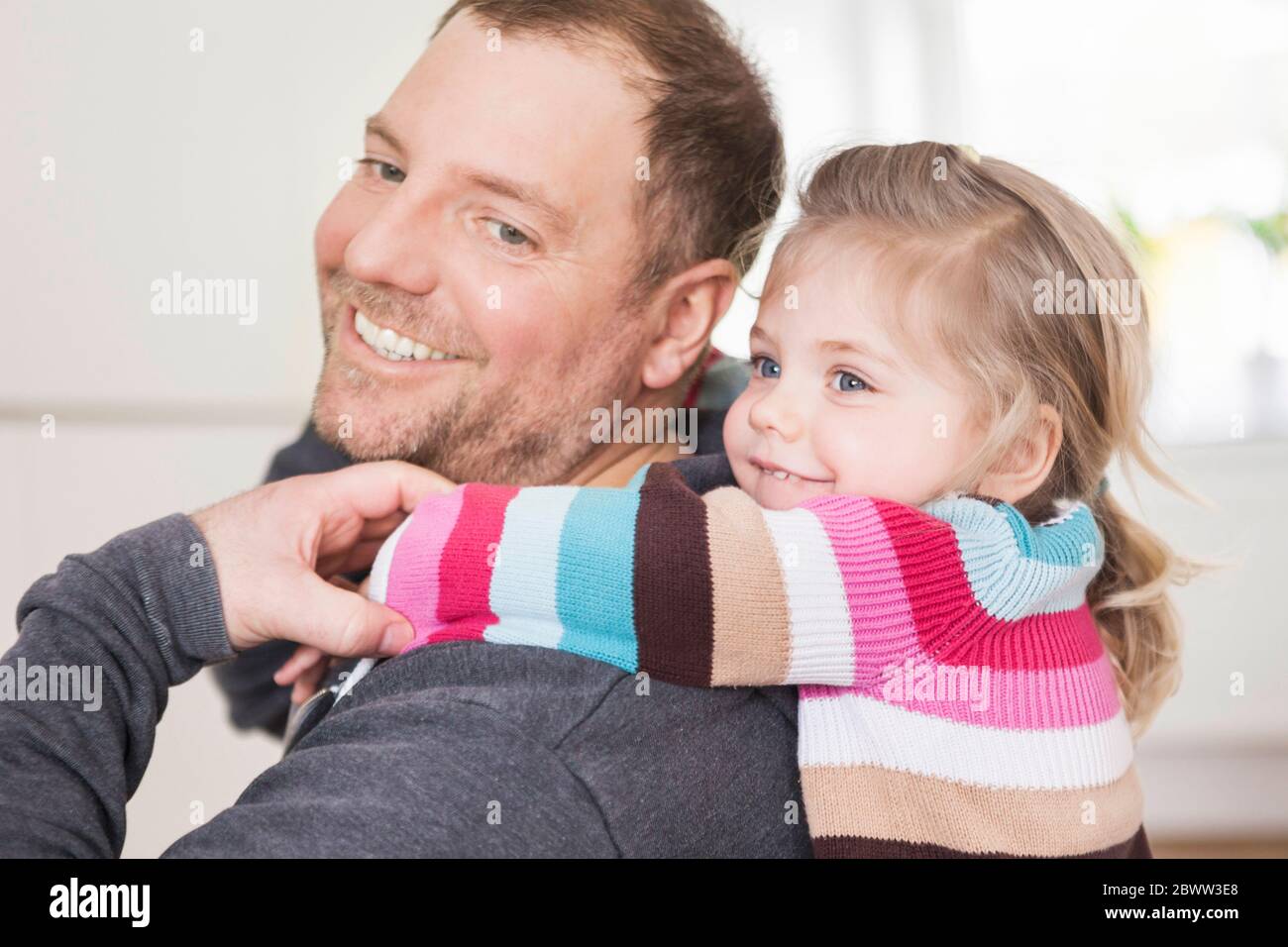 Father cuddling with his daughter at home Stock Photo - Alamy