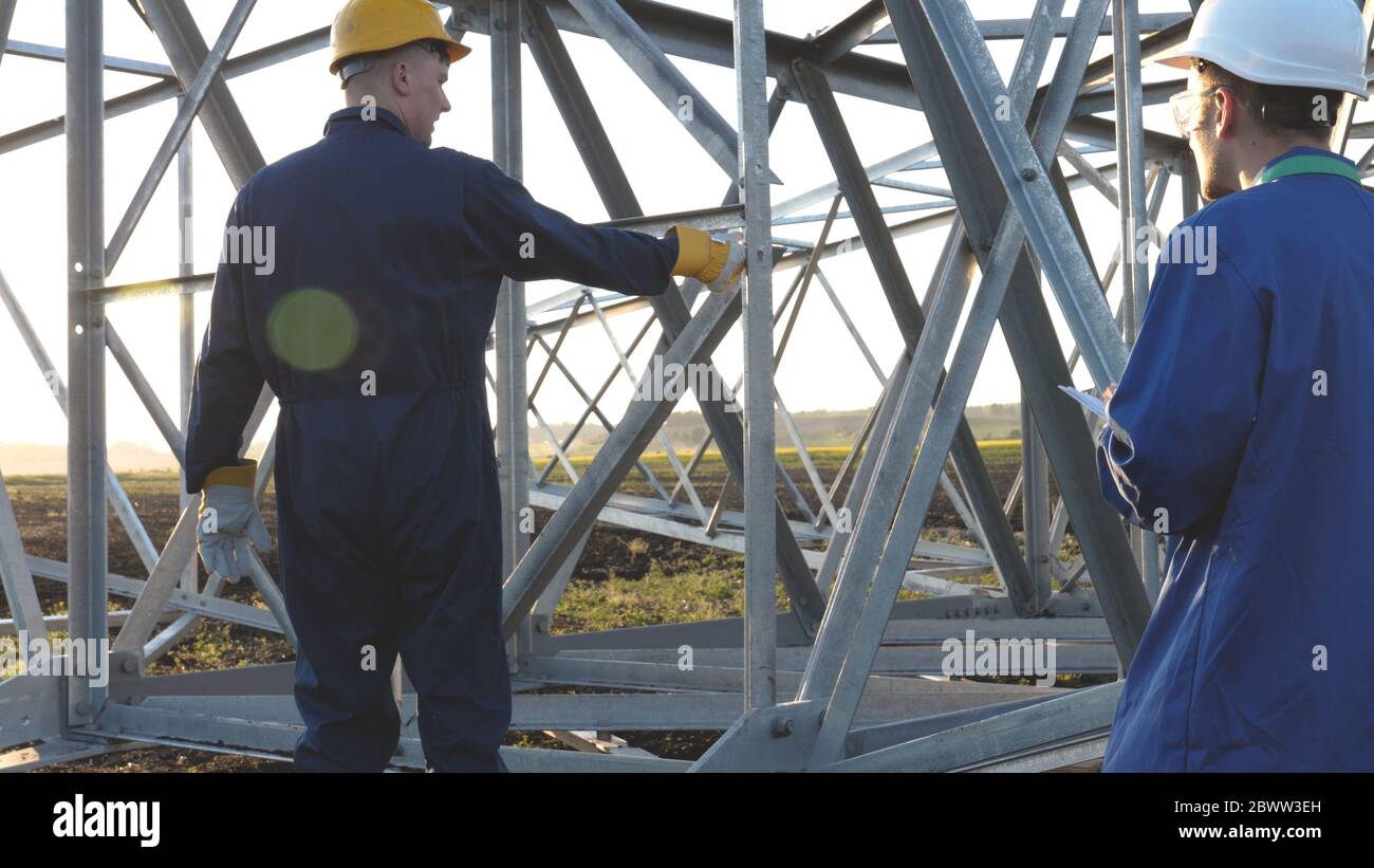 An electrician or builder and engineer, in a blue robe, in a yellow and ...