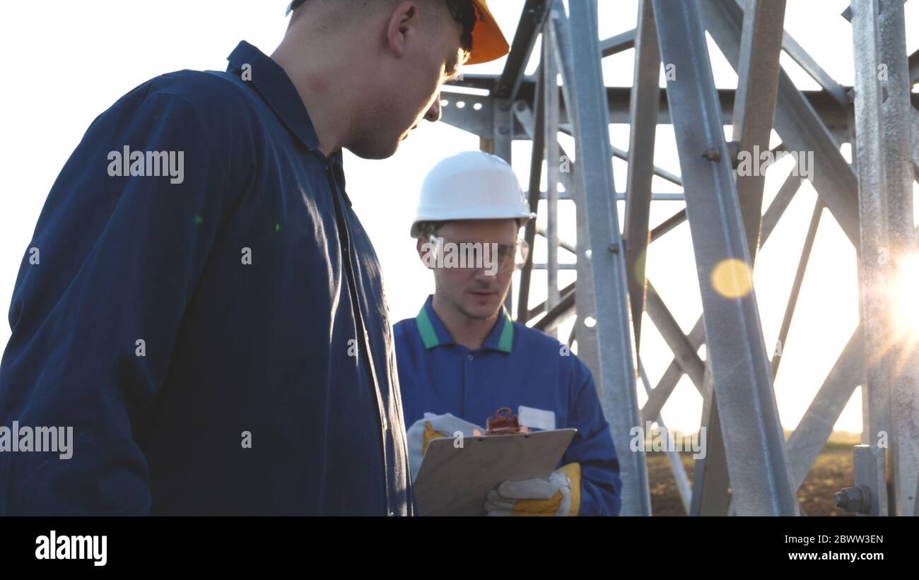 An electrician or builder and engineer, in a blue robe, in a yellow and ...