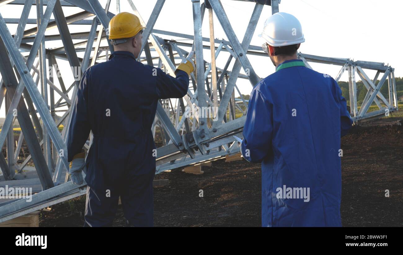 An electrician or builder and engineer, in a blue robe, in a yellow and ...