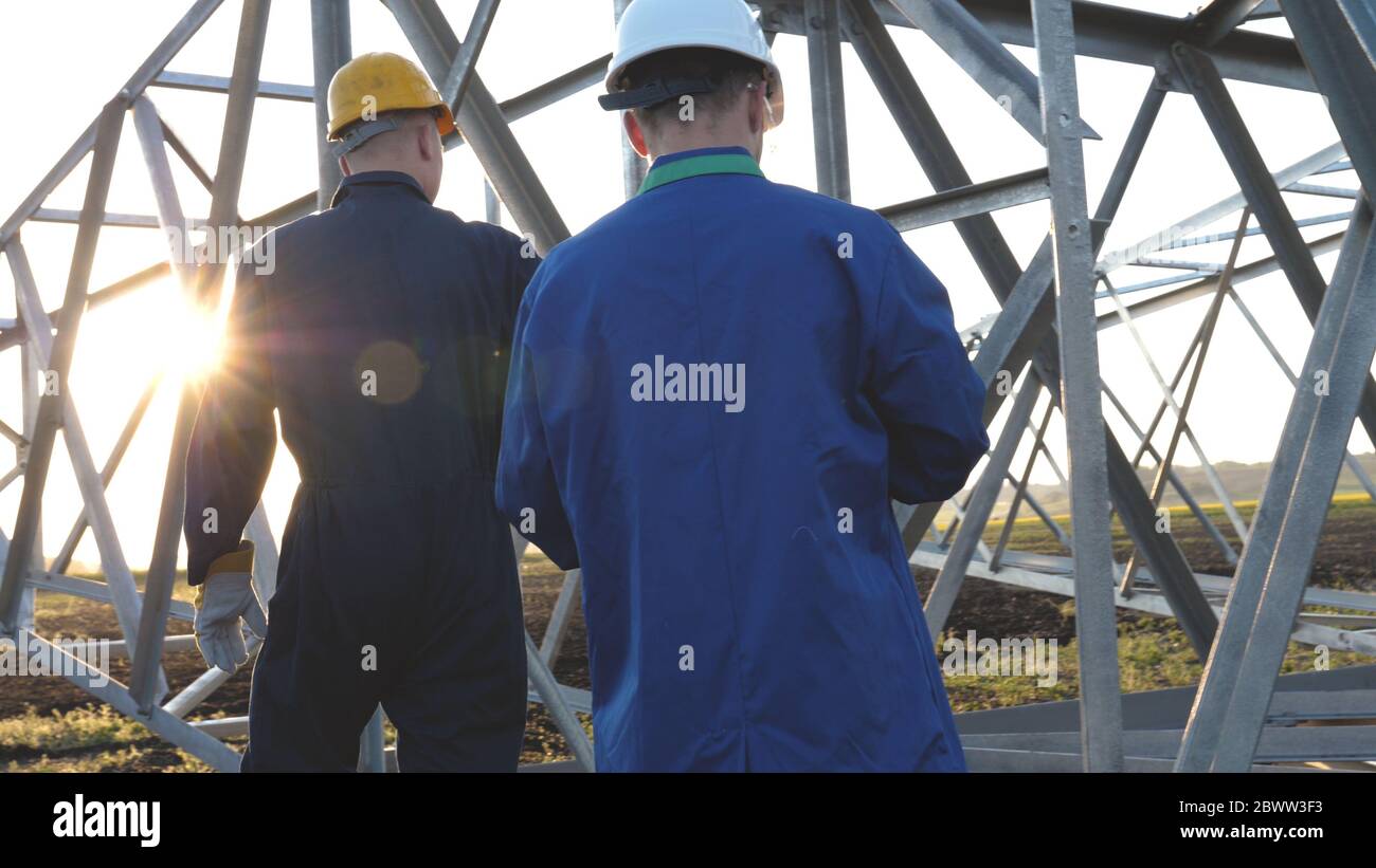 An electrician or builder and engineer, in a blue robe, in a yellow and ...