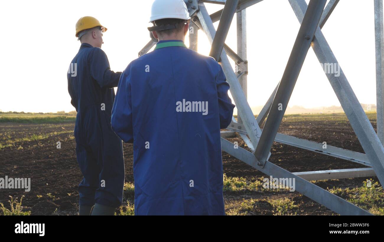 An electrician or builder and engineer, in a blue robe, in a yellow and ...