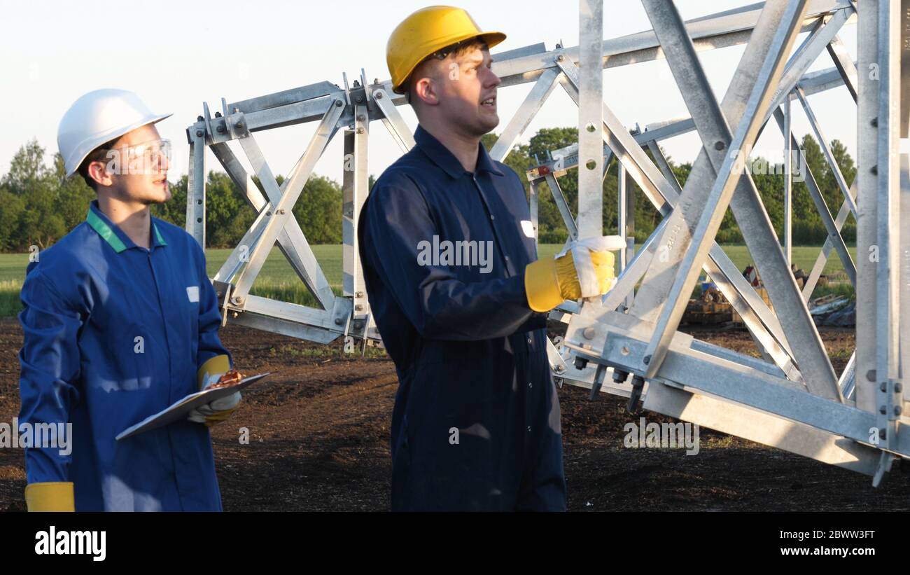 An electrician or builder and engineer, in a blue robe, in a yellow and ...