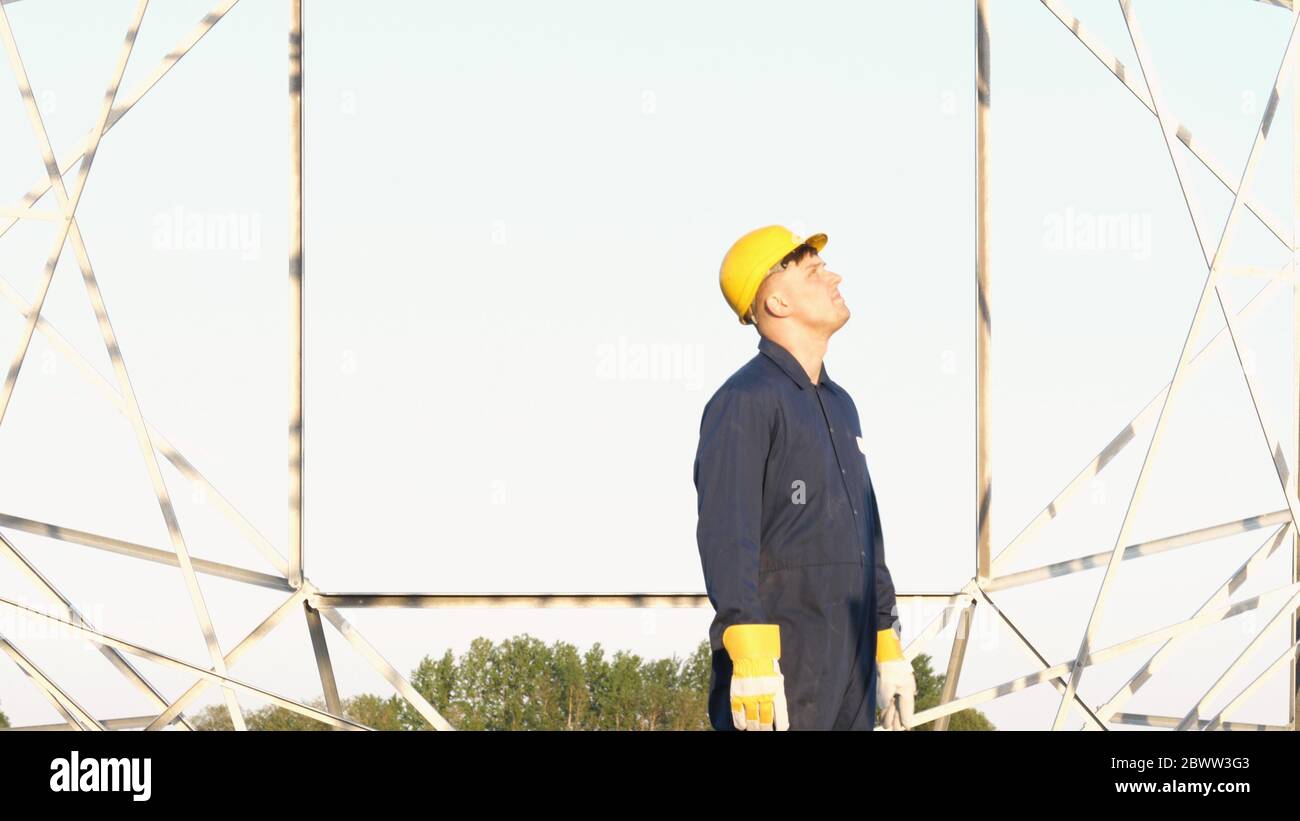 An electrician or builder and engineer, in a blue robe, in a yellow and ...