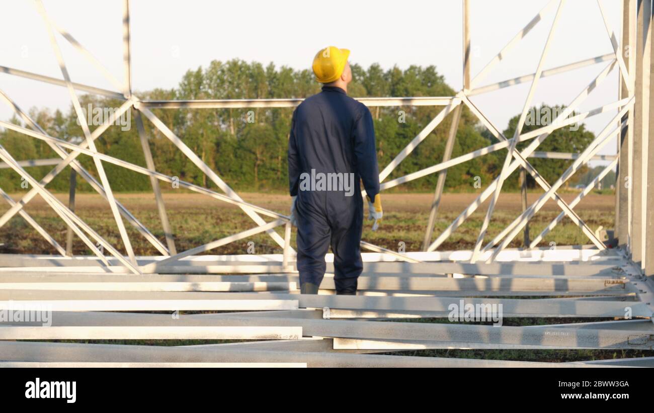 An electrician or builder and engineer, in a blue robe, in a yellow and ...