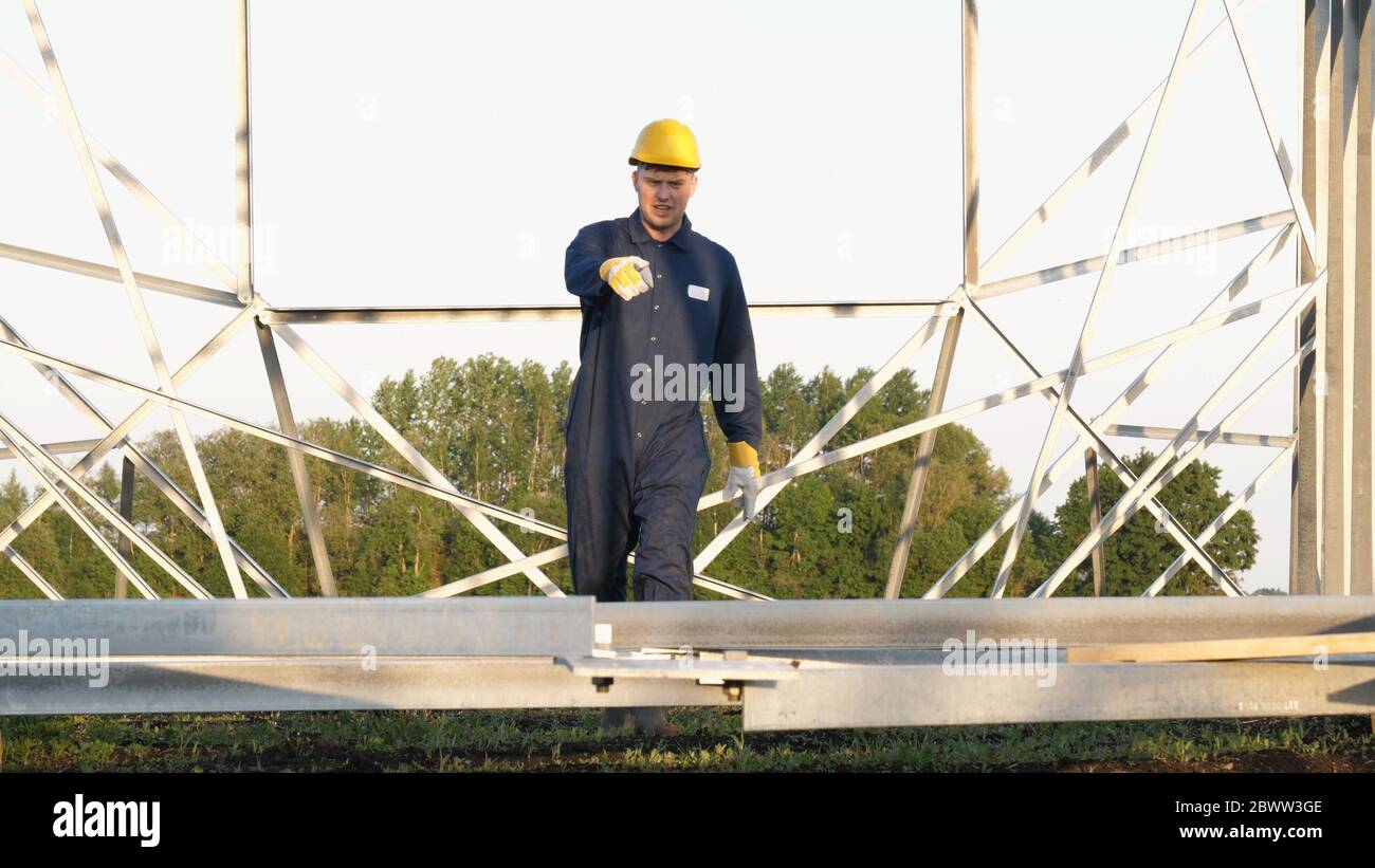 An electrician or builder and engineer, in a blue robe, in a yellow and ...
