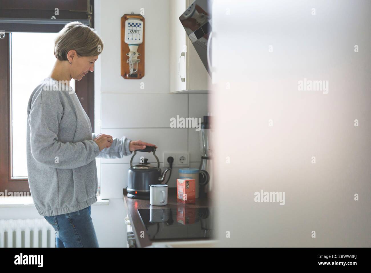 Mature woman preparing tea in kitchen Stock Photo - Alamy