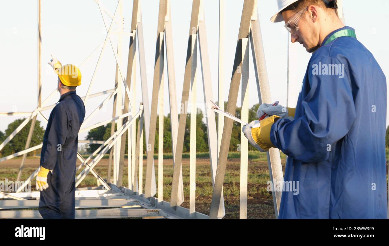 An electrician or builder and engineer, in a blue robe, in a yellow and ...