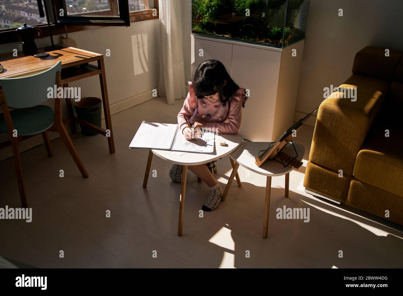 Girl doing homework in the living room Stock Photo - Alamy
