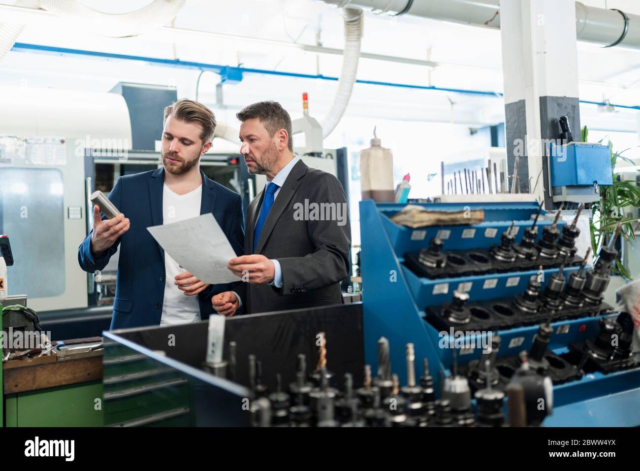 Two businessmen having a work meeting in a factory Stock Photo - Alamy
