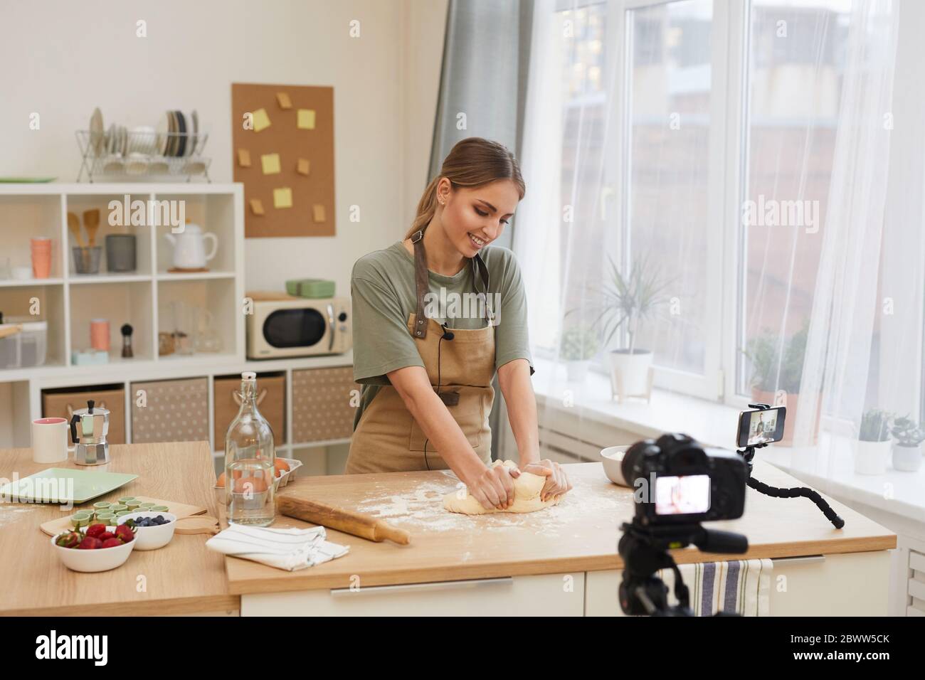 Food blogger cooking in the kitchen and shooting the process on the ...