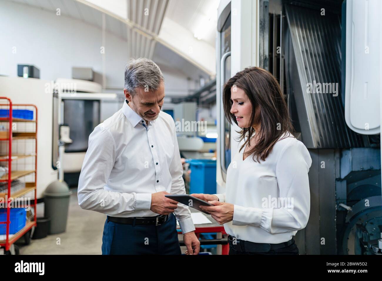 Businessman and businesswoman with tablet having a work meeting in a ...